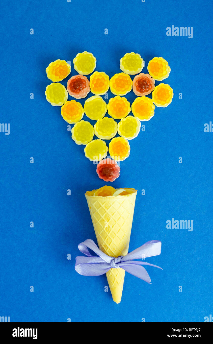 Creative photo of waffle cone with jelly candies on bright color ...