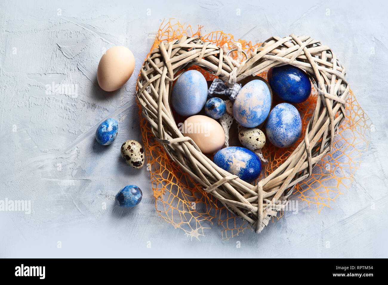 Easter eggs in heart shaped nest. Top view with copy space. Blue Easter ...