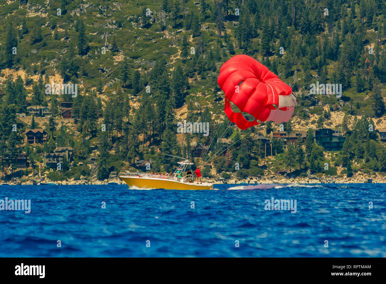 Red parasail wing pulled by a boat on lake Tahoe in California, USA ...