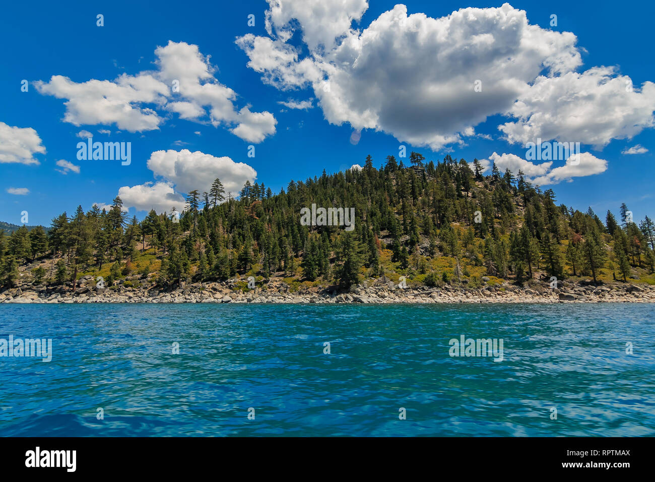 Mountains seen on shore across the crystal clear turquoise water, from ...