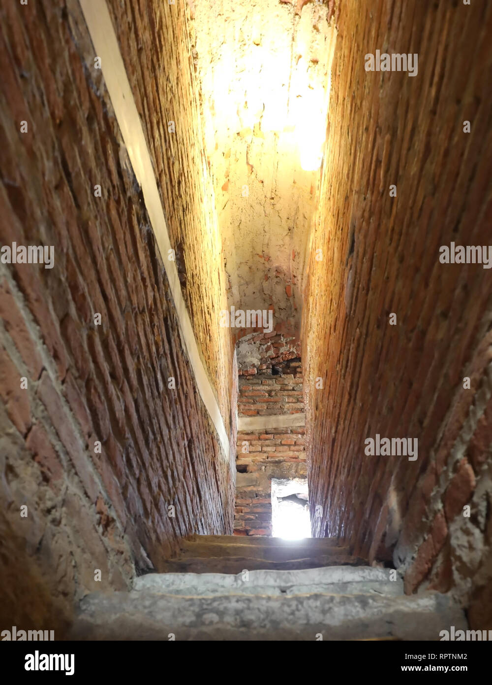 narrow passage with steps to descend from the old medieval tower Stock ...