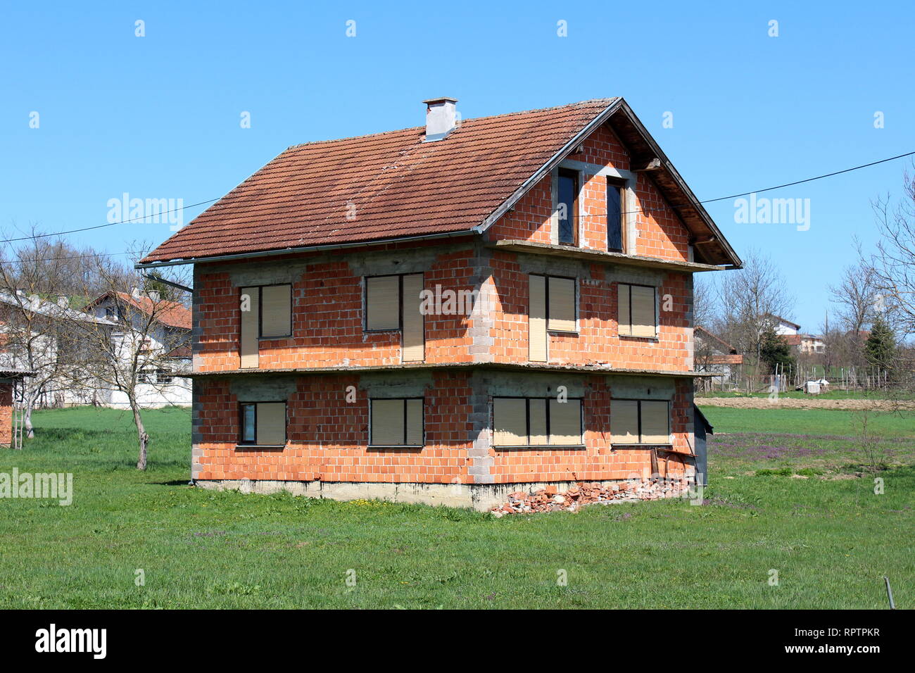 Abandoned unfinished red brick house with completely closed window ...