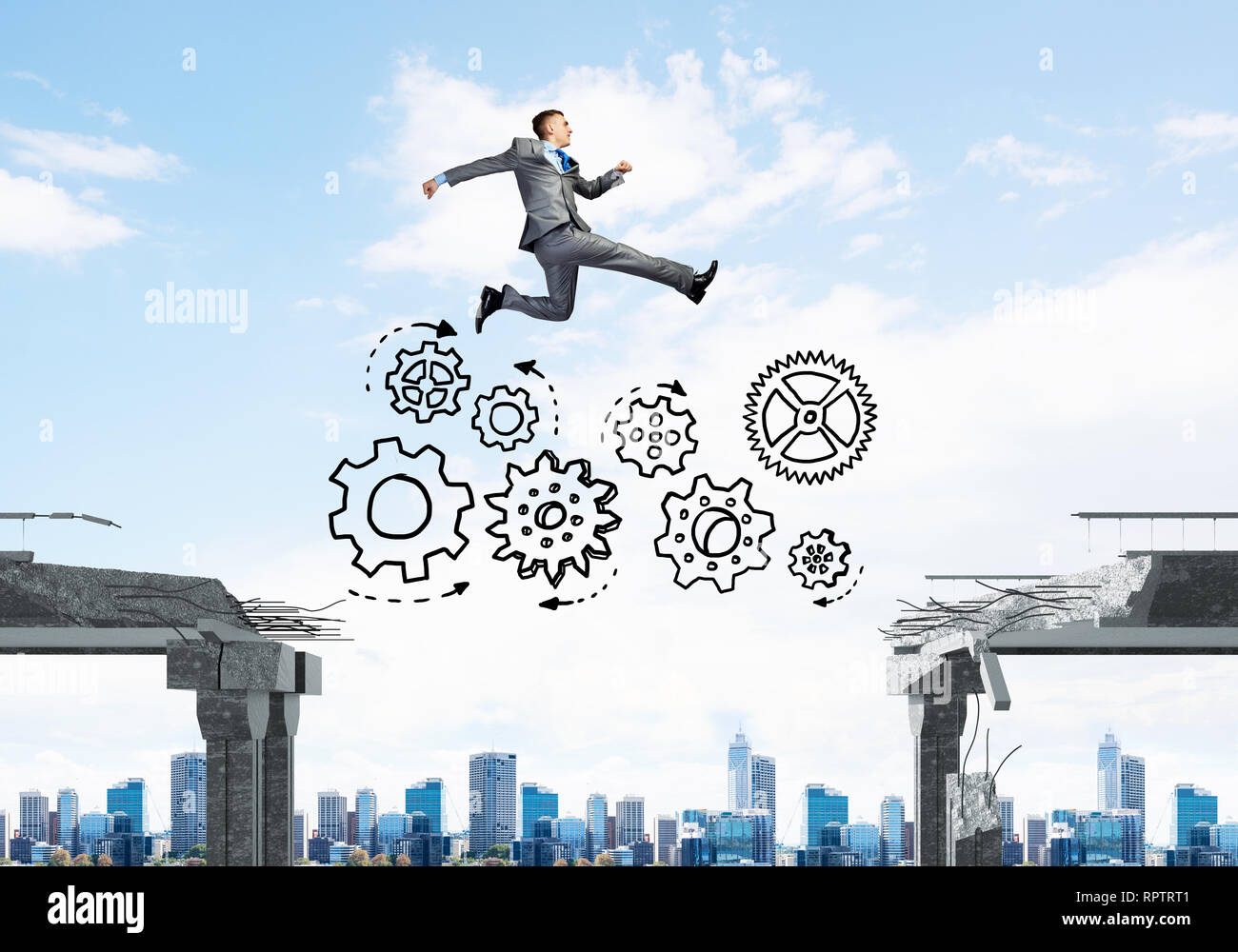 Businessman jumping over gap with gear mechanism in concrete bridge as ...