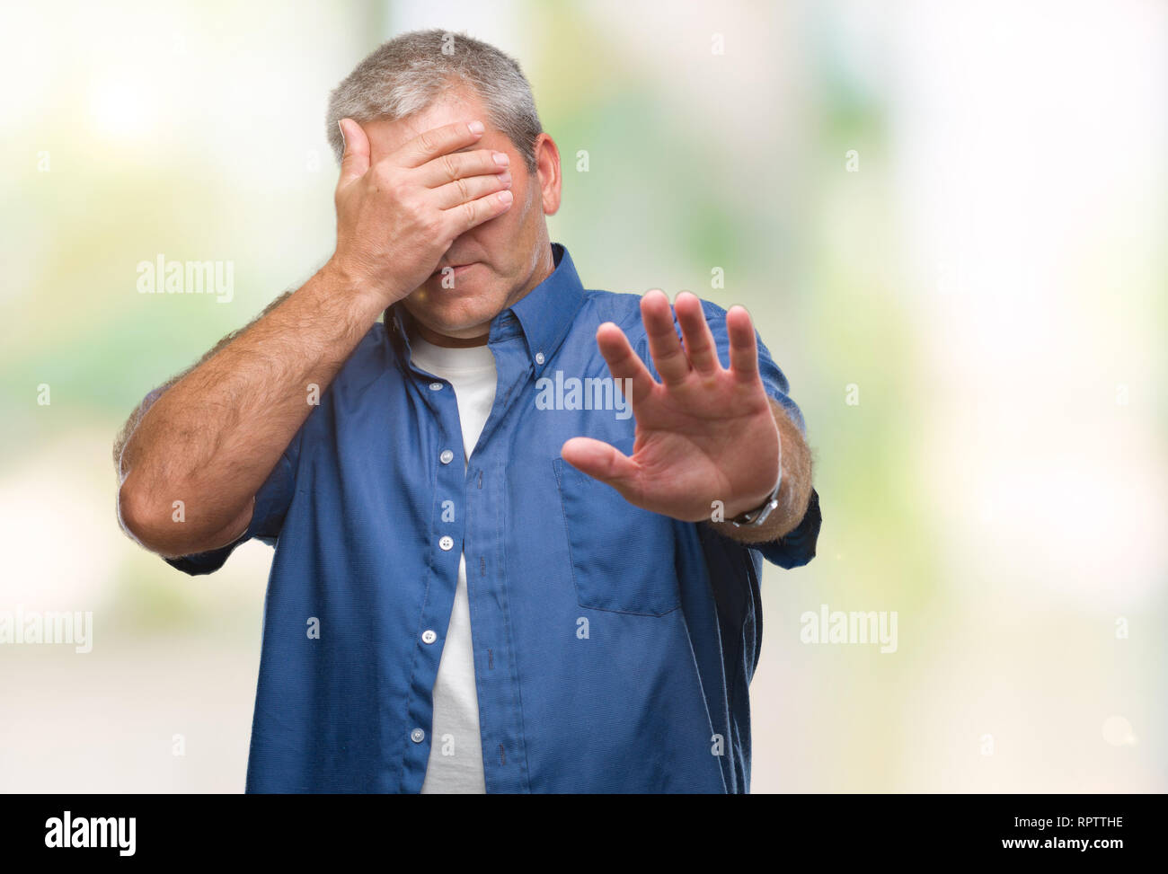 Handsome senior man over isolated background covering eyes with hands ...