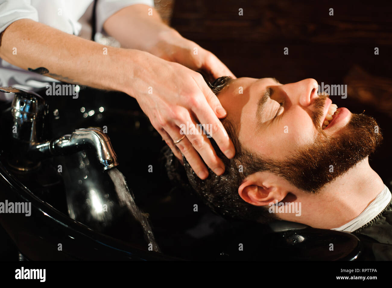 Master cuts hair and beard of men in the barbershop Stock Photo - Alamy