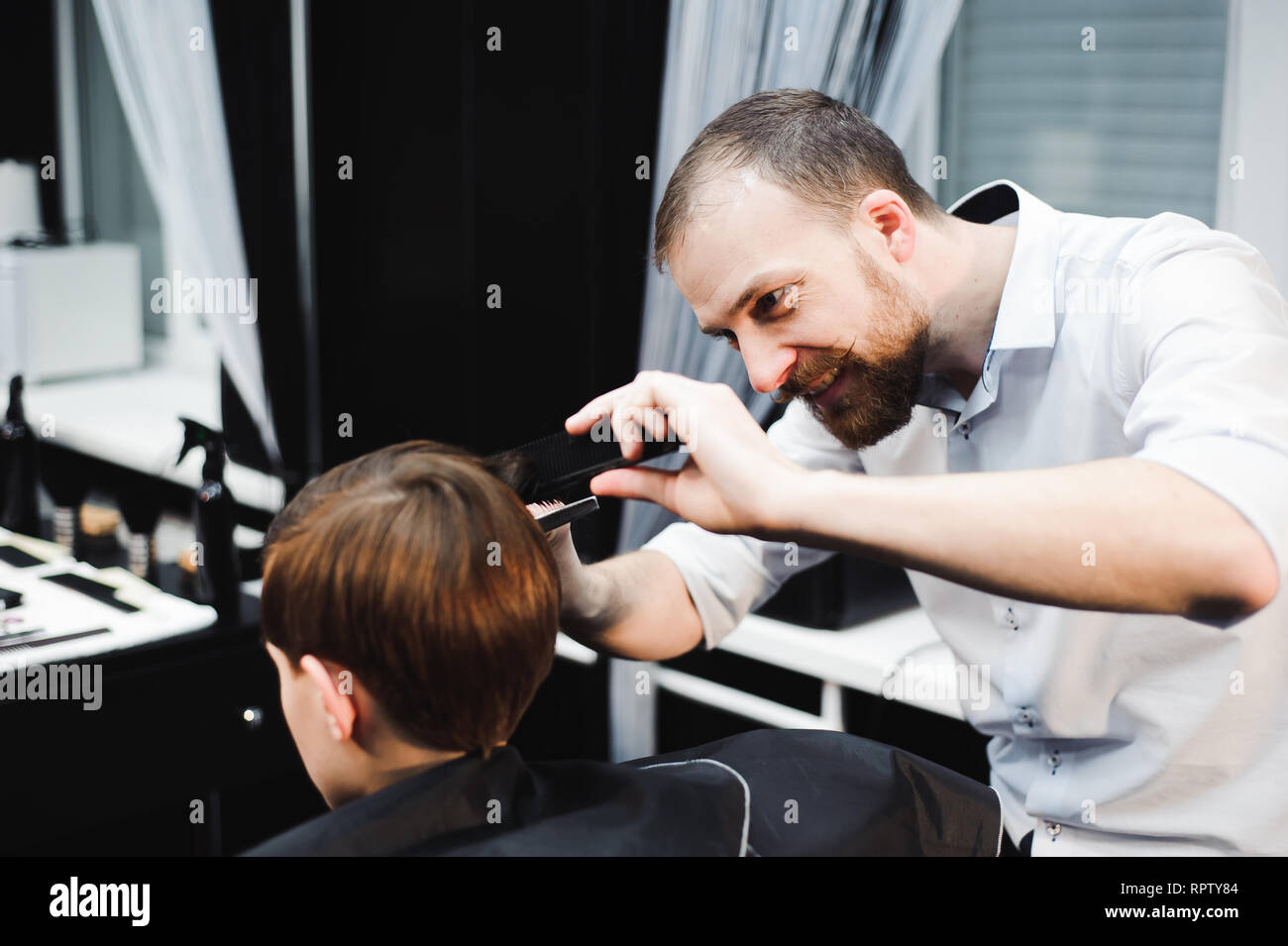 Cute young boy getting a haircut in barbershop Stock Photo - Alamy