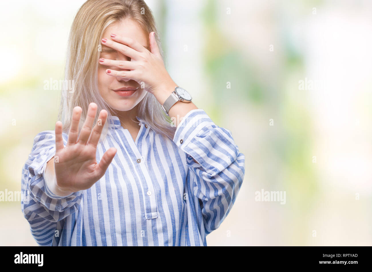 Young blonde woman over isolated background covering eyes with hands ...