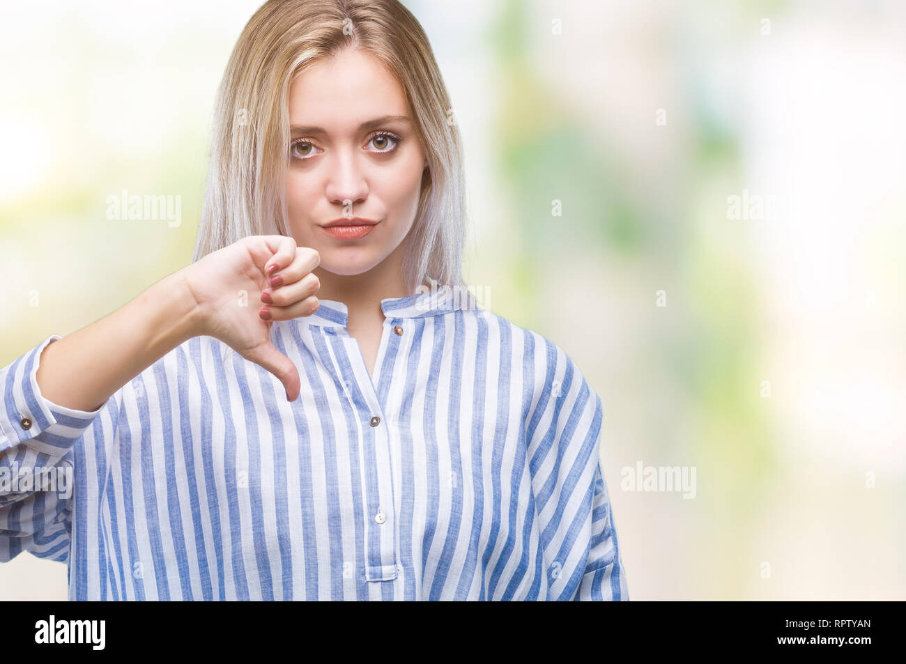 Young blonde woman over isolated background looking unhappy and angry ...