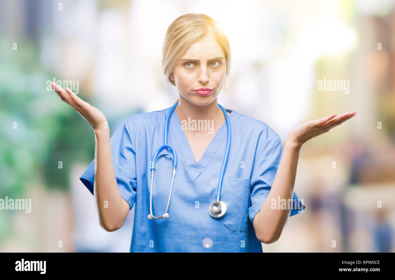 Young beautiful blonde doctor surgeon nurse woman over isolated ...