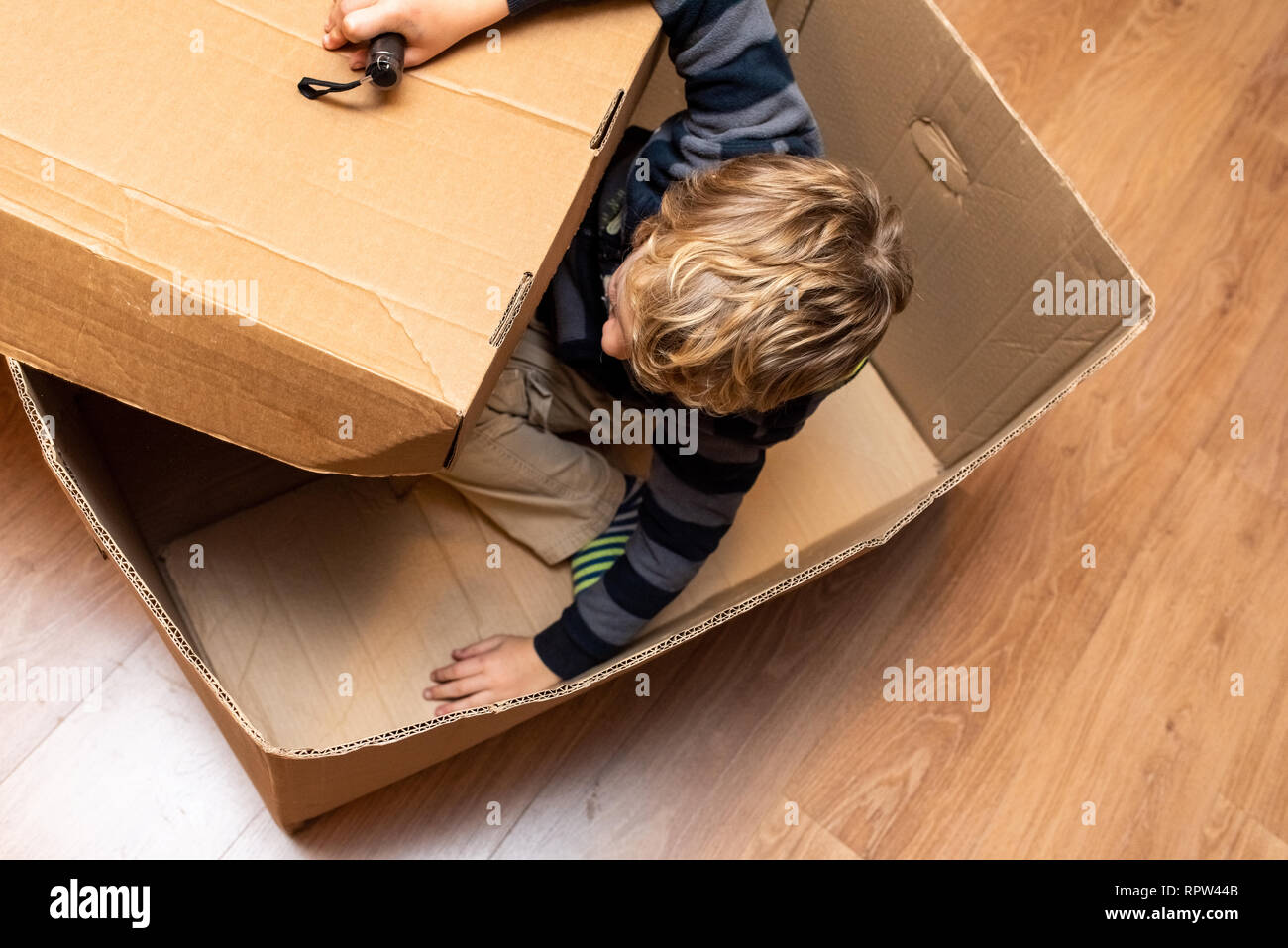 Child playing inside a cardboard box Stock Photo - Alamy