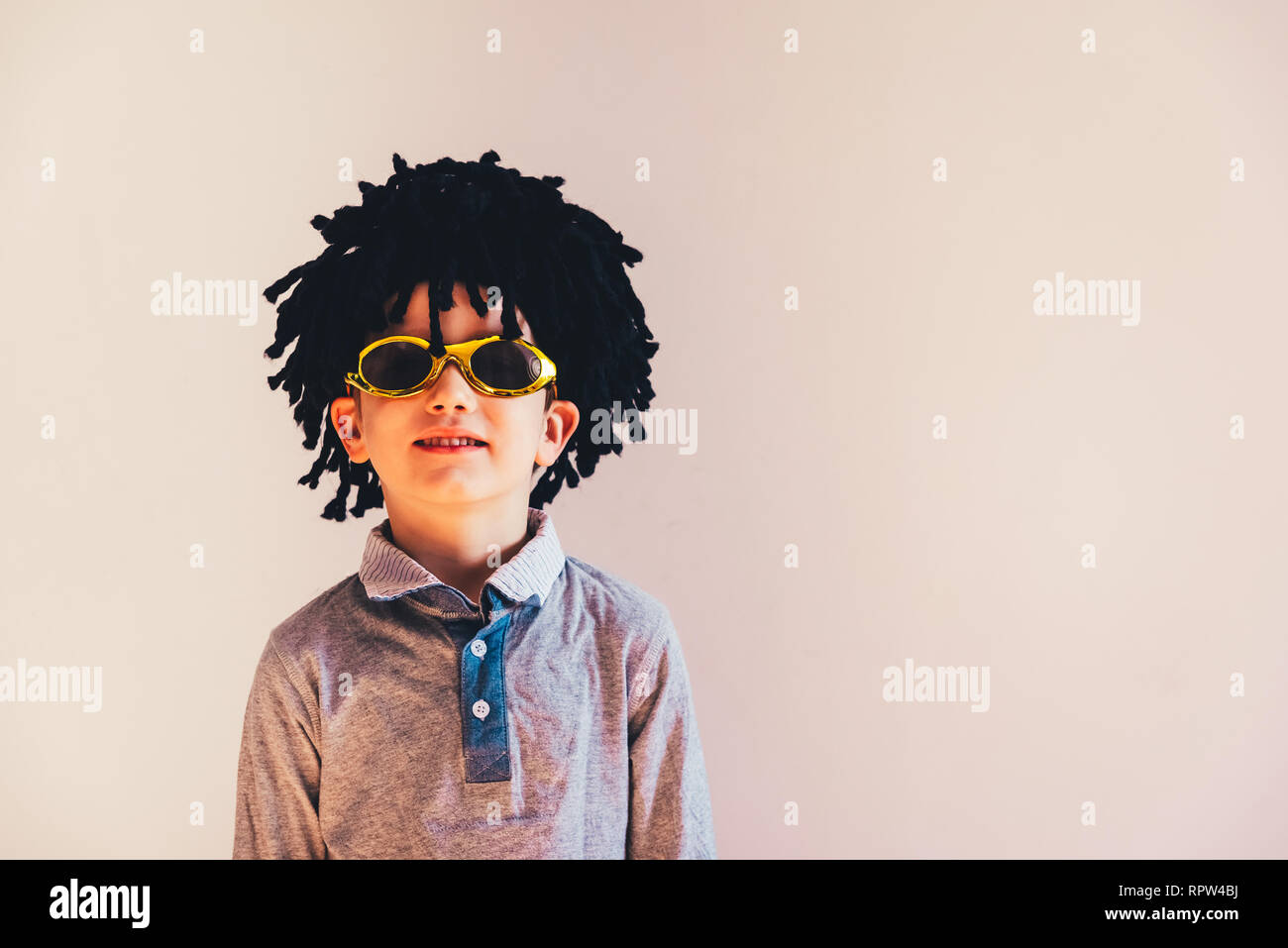 Child with rastafari wig dancing cheerful, isolated copy space white ...