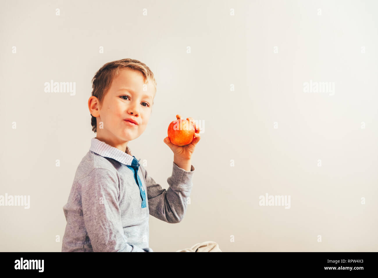 Child ready to eat an apple at a bite, isolated on white background ...