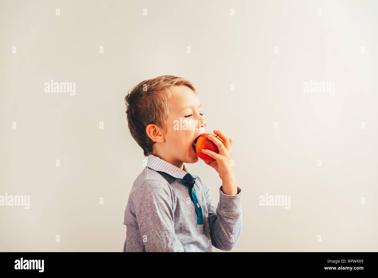 Child ready to eat an apple at a bite, isolated on white background ...