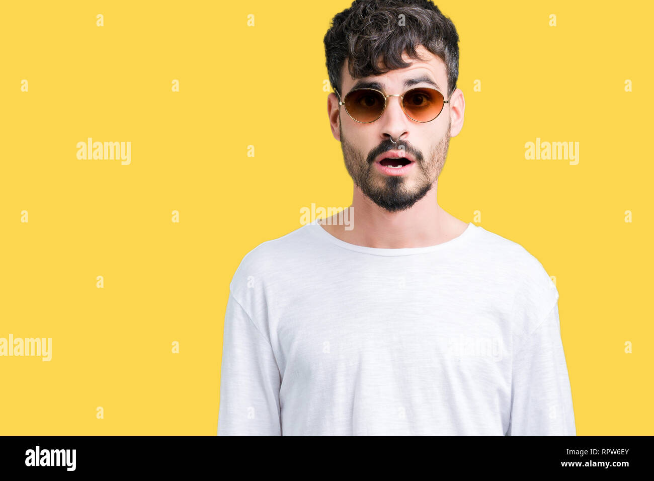 Young handsome man wearing sunglasses over isolated background afraid and shocked with surprise ...