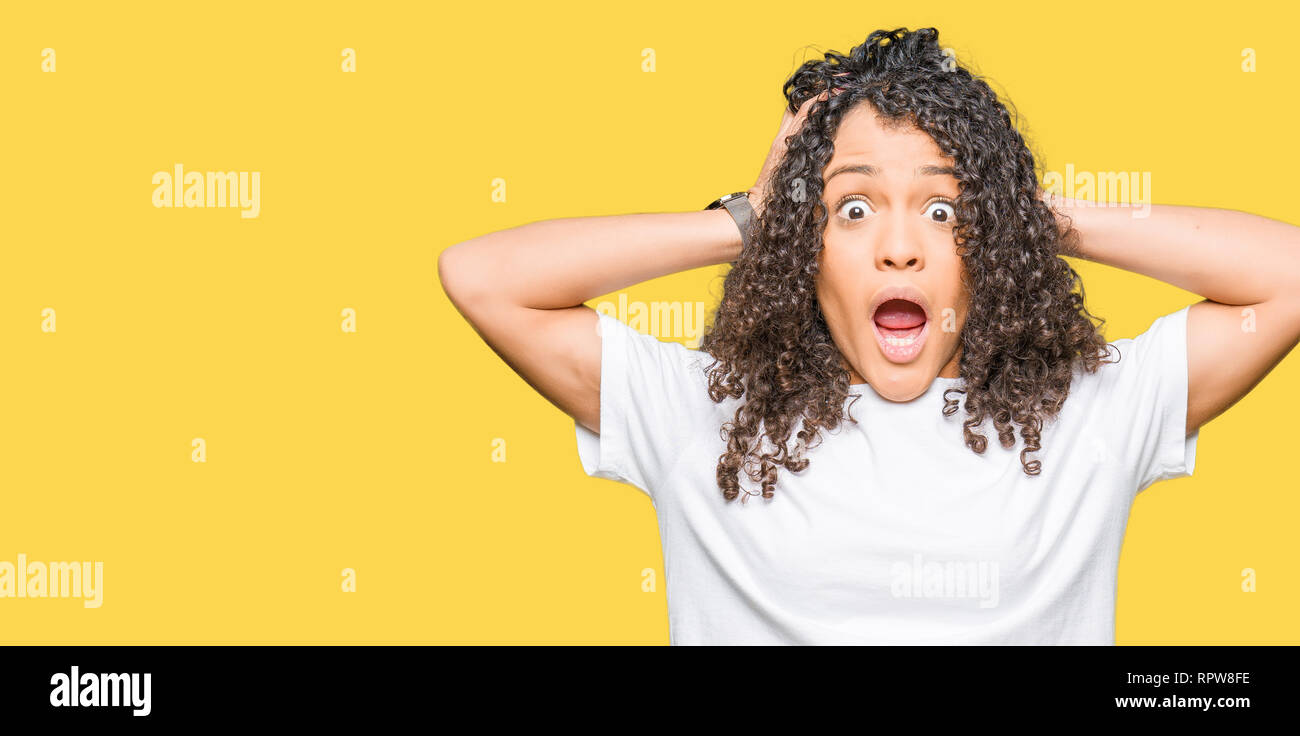 Young beautiful woman with curly hair wearing white t-shirt Crazy and ...