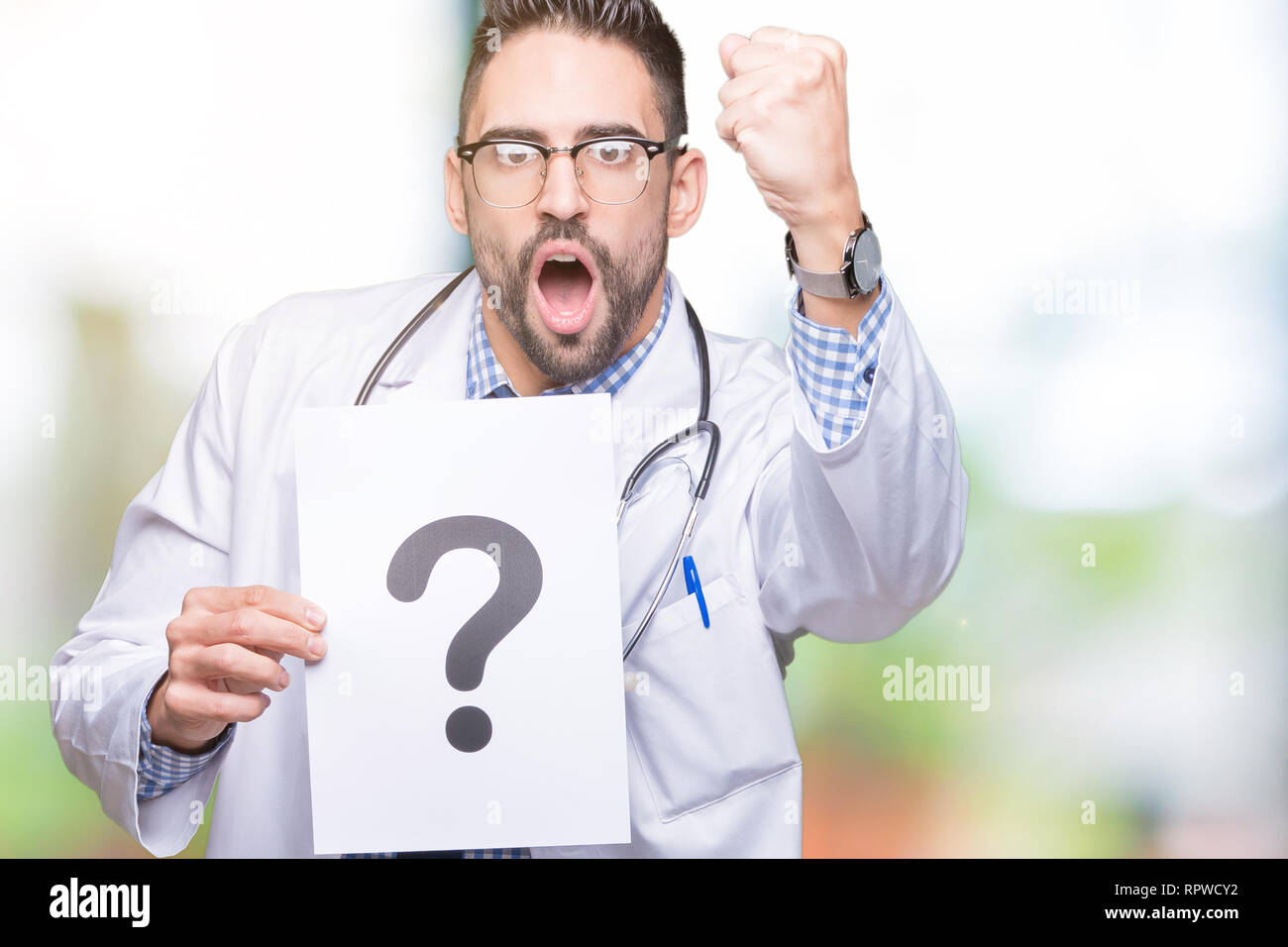 Handsome young doctor man holding paper with question mark over ...