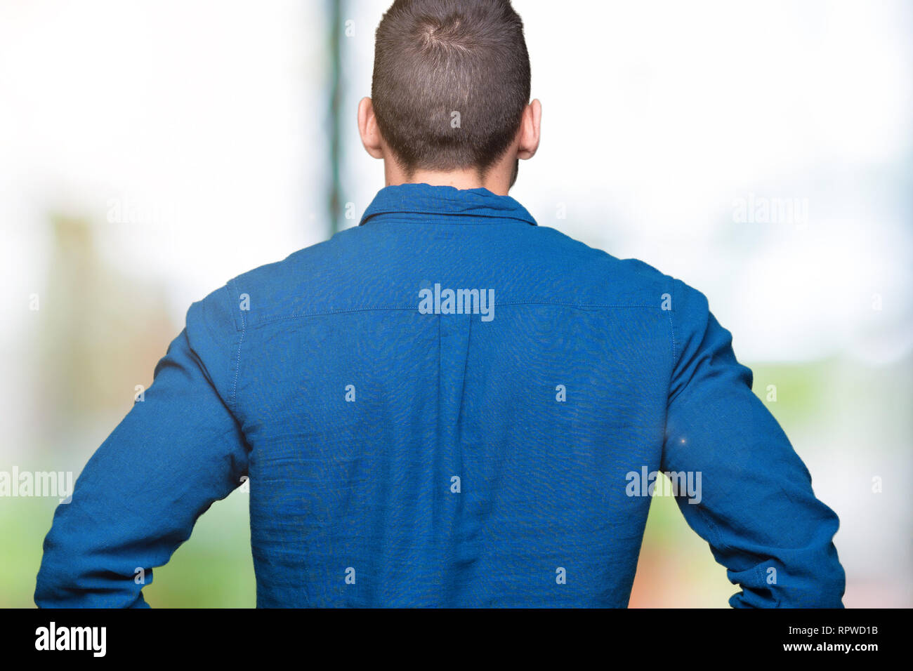 Young handsome man over isolated background standing backwards looking ...