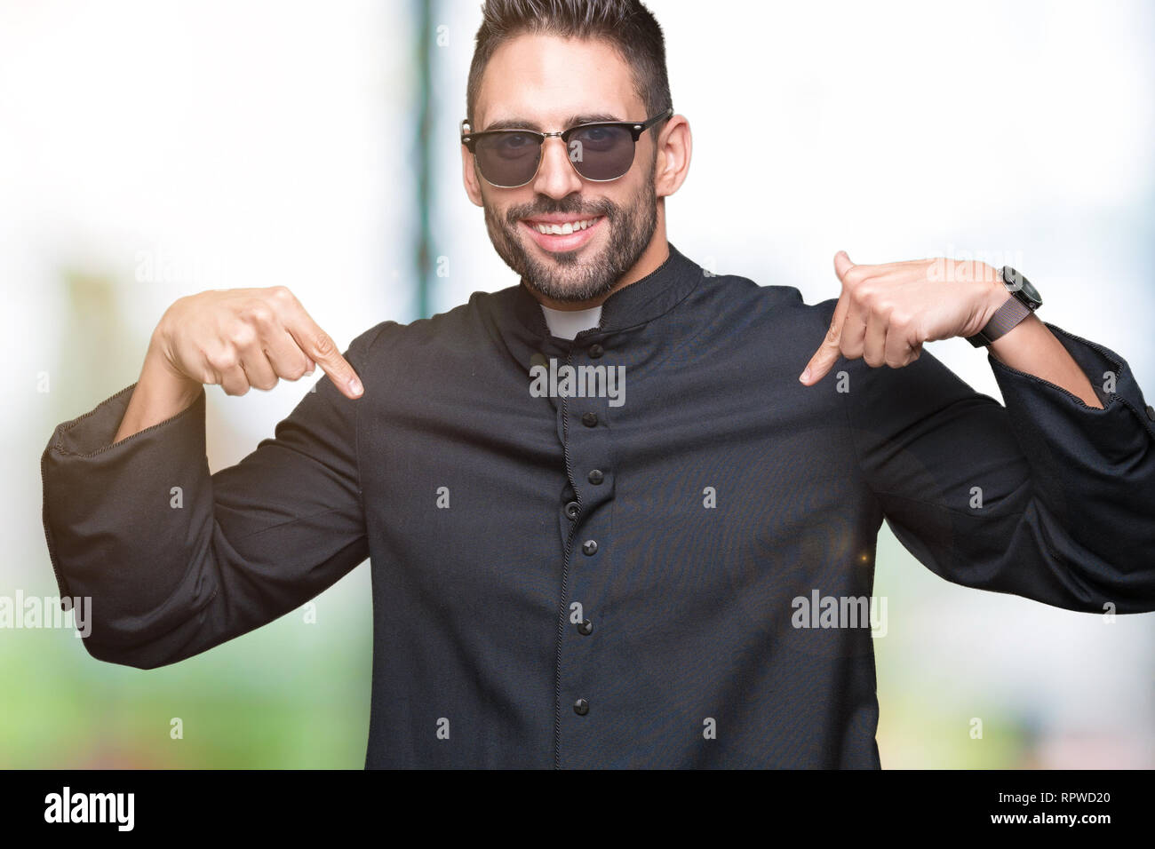 Young Christian priest wearing sunglasses over isolated background ...