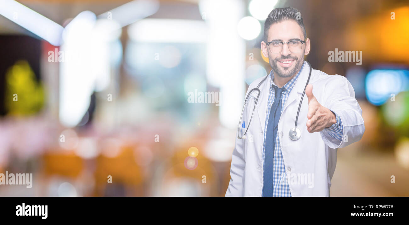 Handsome young doctor man over isolated background smiling friendly ...