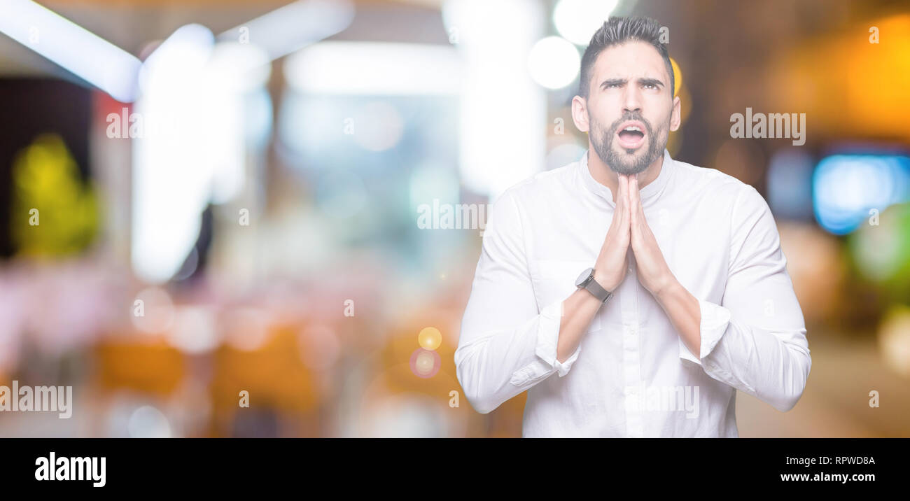 Young business man over isolated background begging and praying with ...
