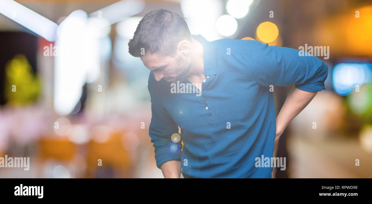 Young handsome man over isolated background Suffering of backache ...