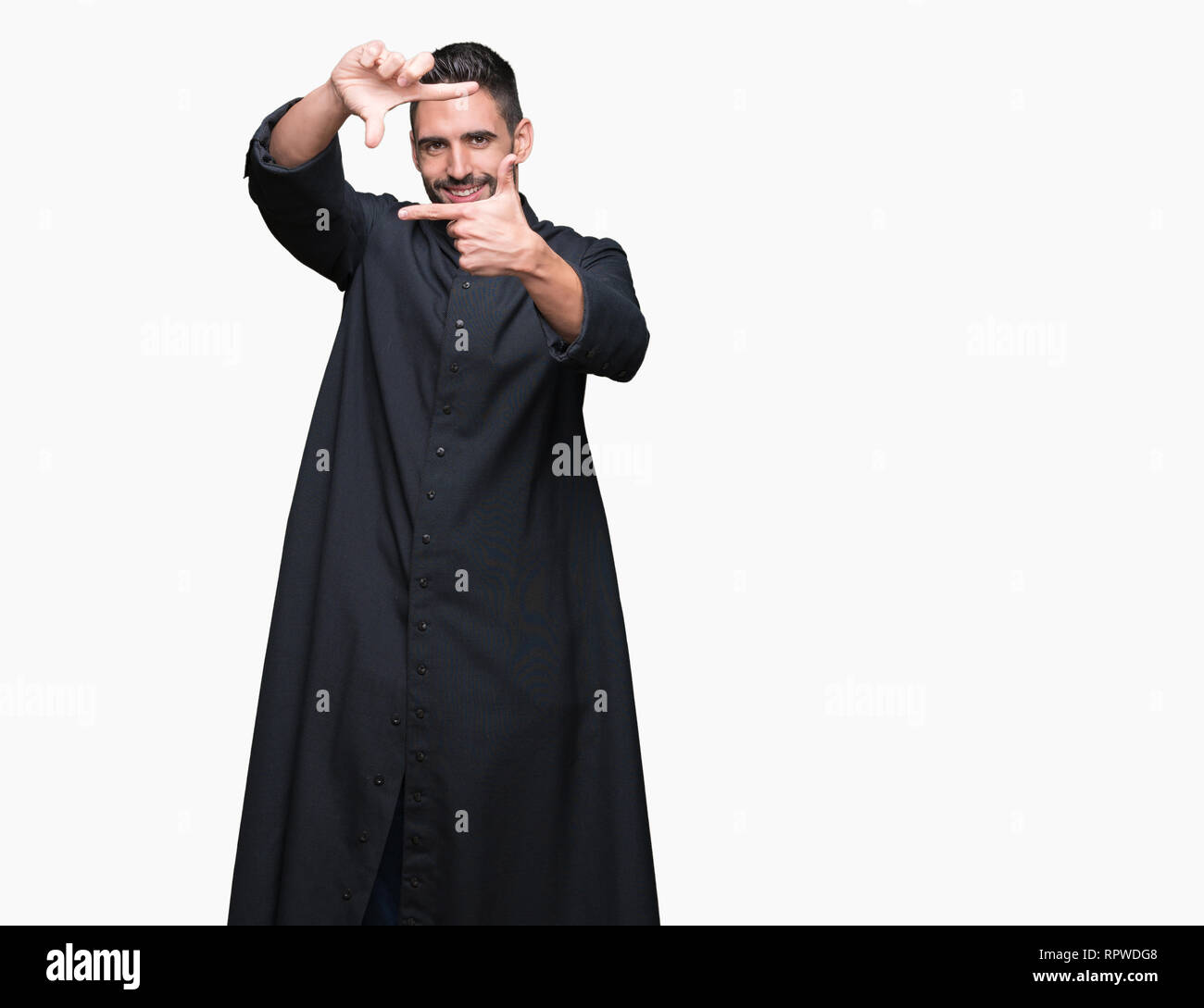 Young Christian priest over isolated background smiling making frame ...