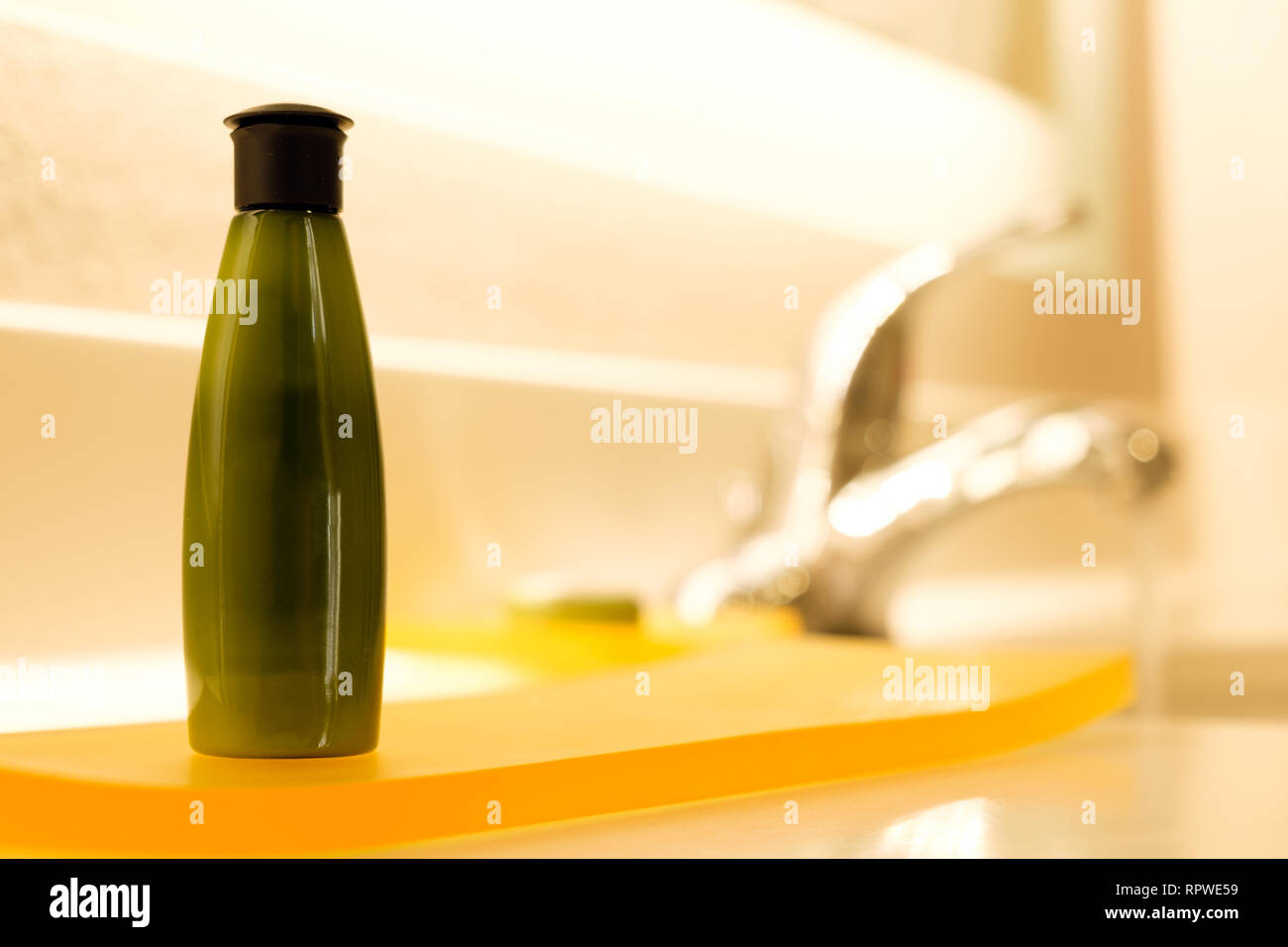 Green small shampoo container in bathroom Stock Photo - Alamy