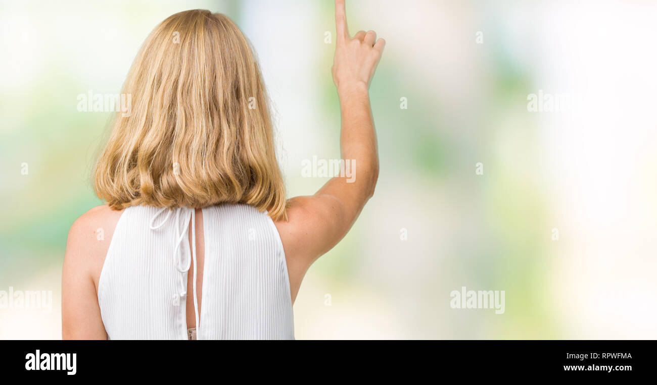 Beautiful young elegant woman over isolated background Posing backwards ...