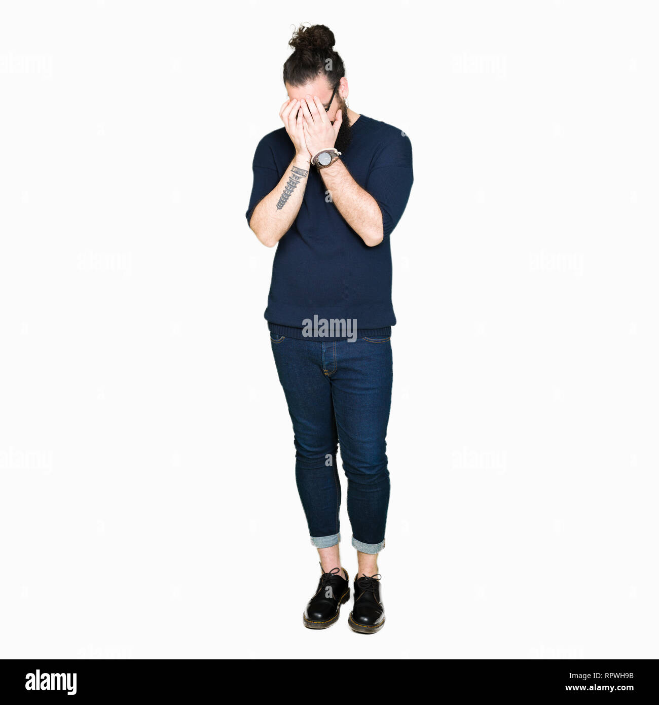 Young hipster man with long hair and beard wearing glasses with sad ...