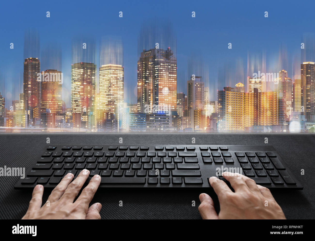Hand typing on computer keyboard and modern buildings Stock Photo - Alamy