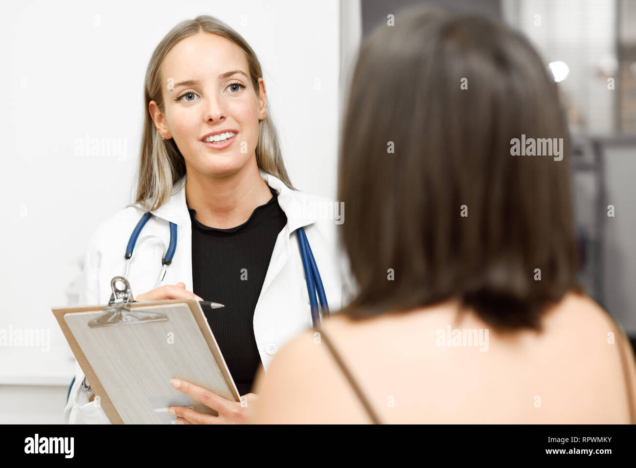 Female doctor explaining diagnosis to her young woman patient Stock ...