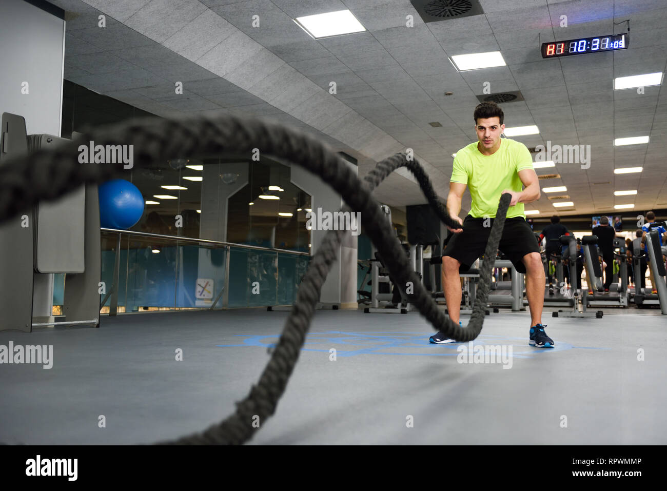 Man with battle ropes exercise in the fitness gym Stock Photo - Alamy