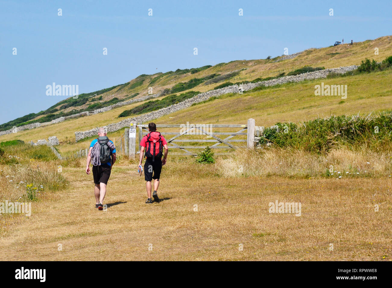 People walking along the coastal path through Durlston Country Park and ...