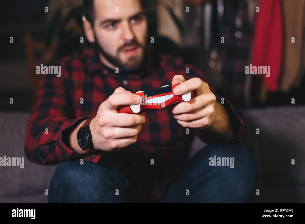 Portrait of a handsome man playing video games in his apartment ...