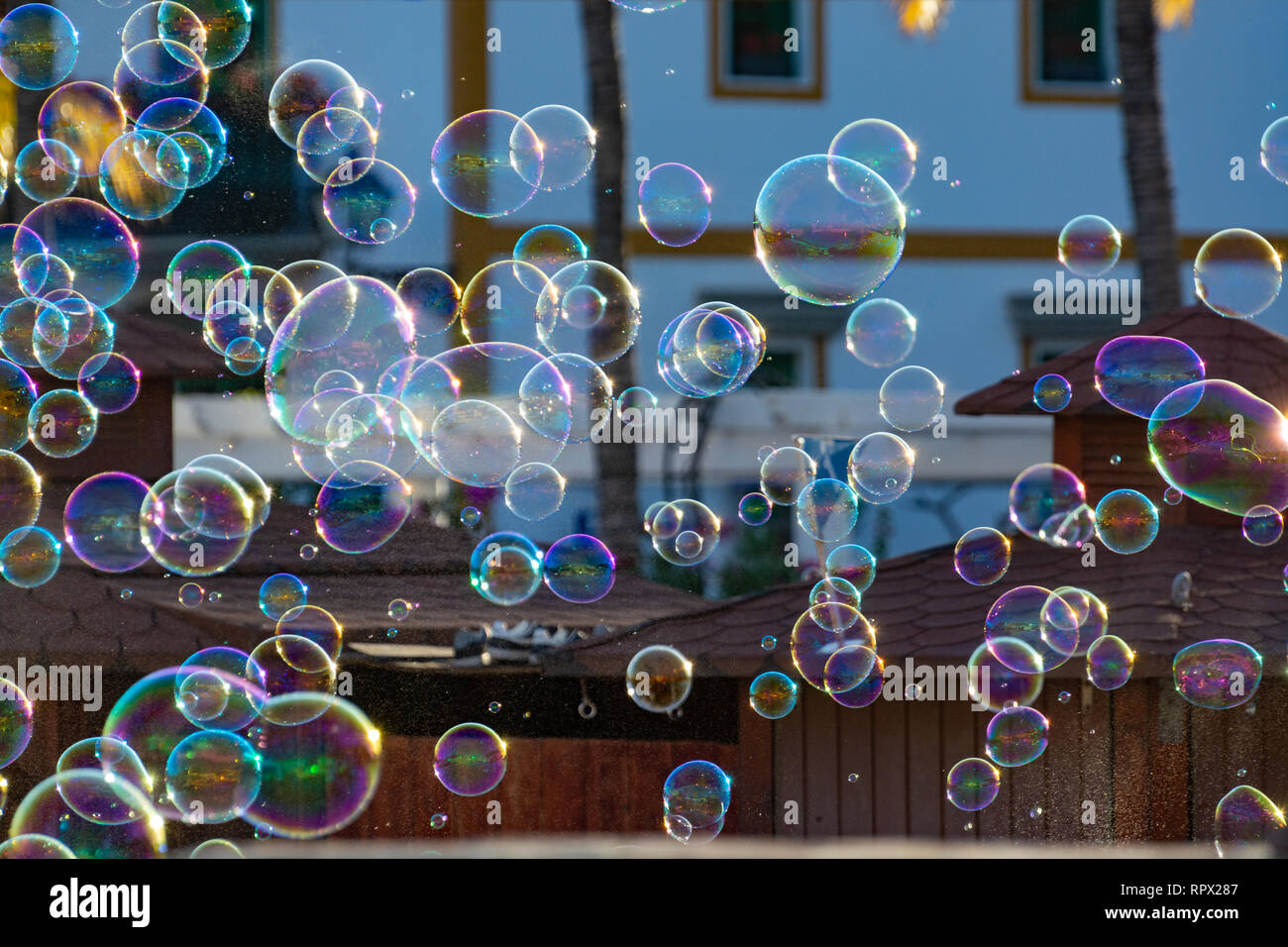 Background with many soap bubbles in air on city street, outdoor fun ...