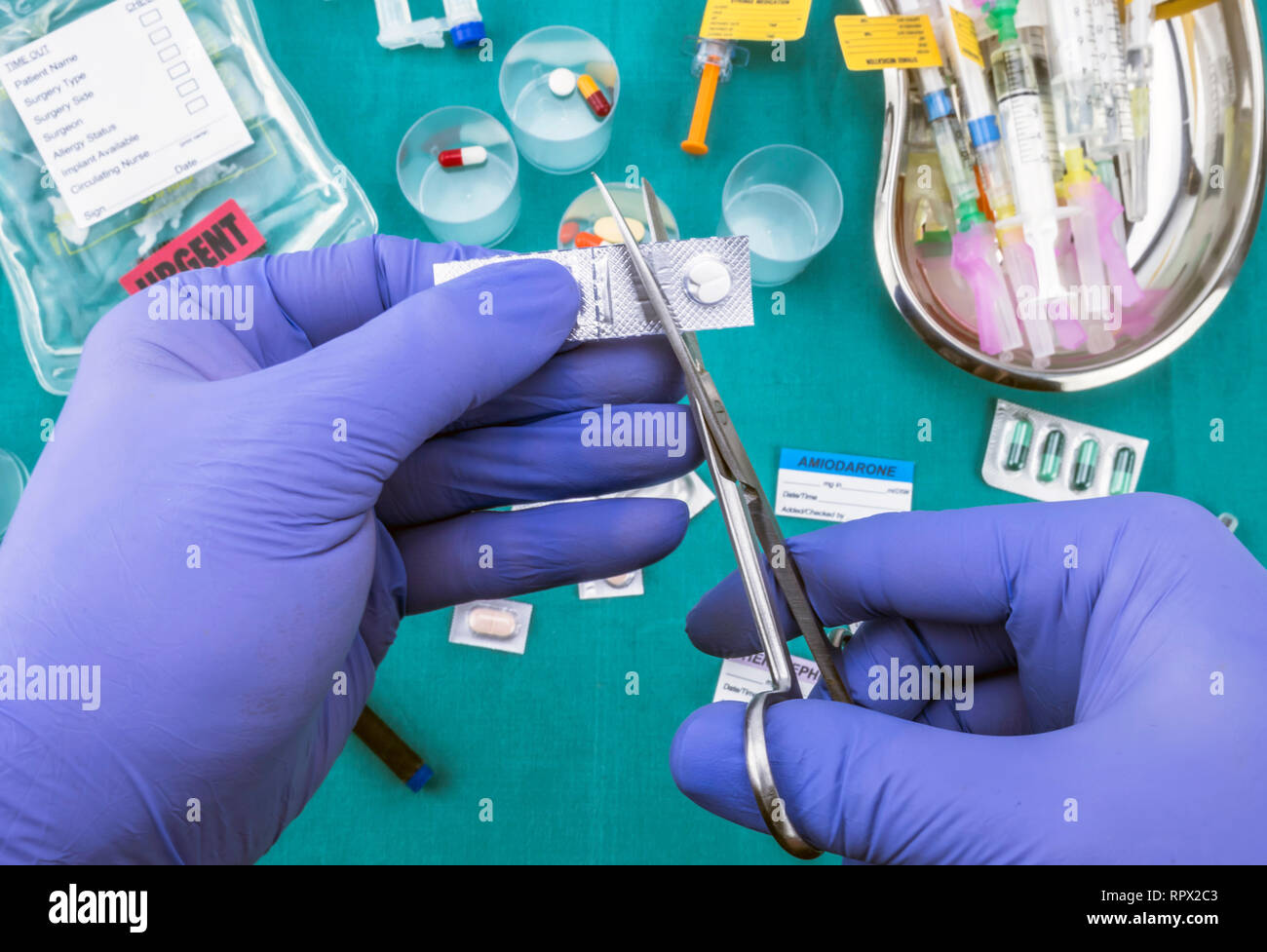 Nurse preparing hospital medication, cutting with scissors blister of ...