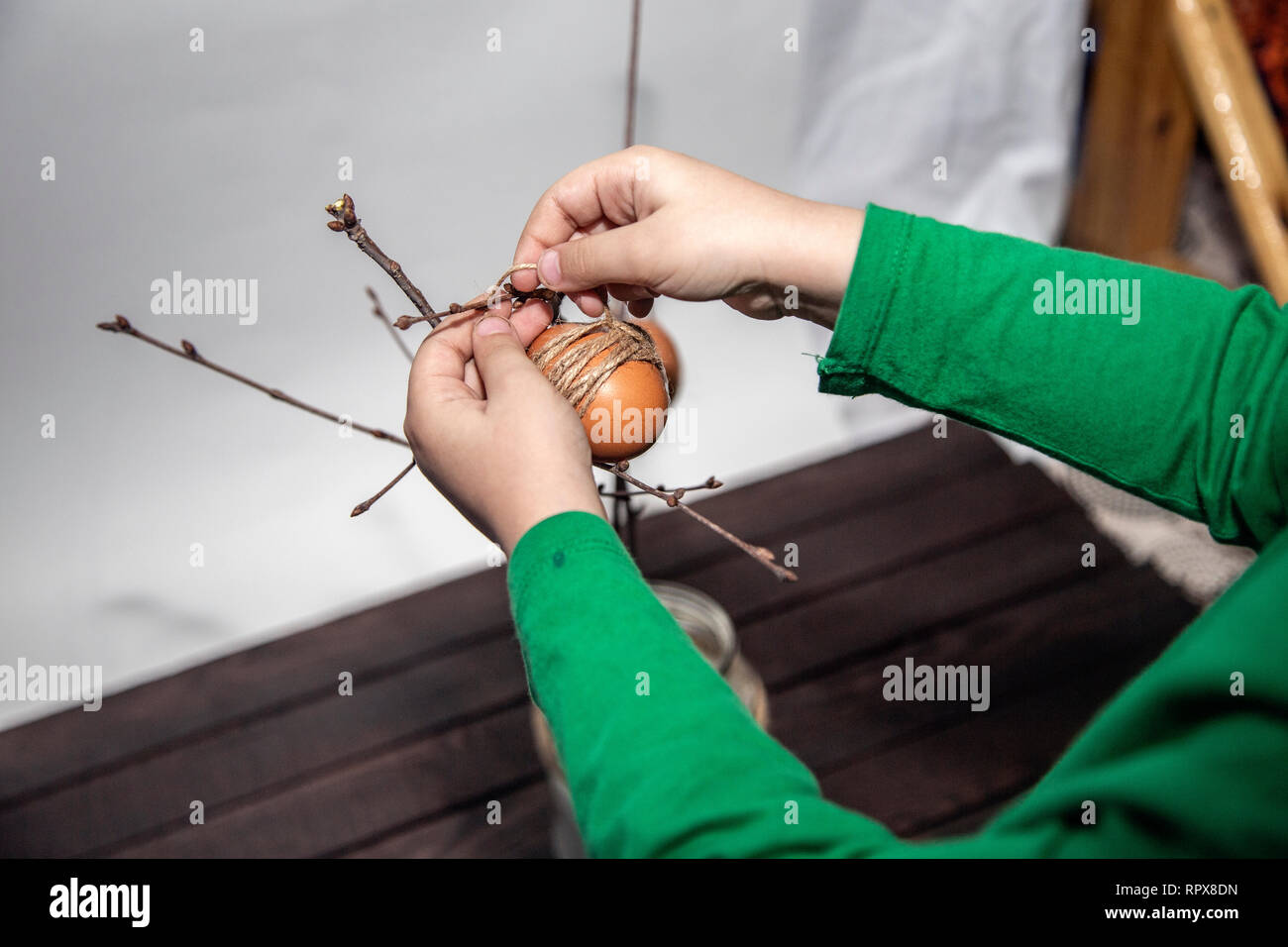 Easter holiday preparations. Little boy hanging easter eggs on the ...