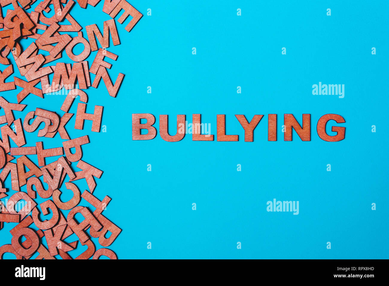 Word Bullying of wooden letters on a blue background. The problem of ...