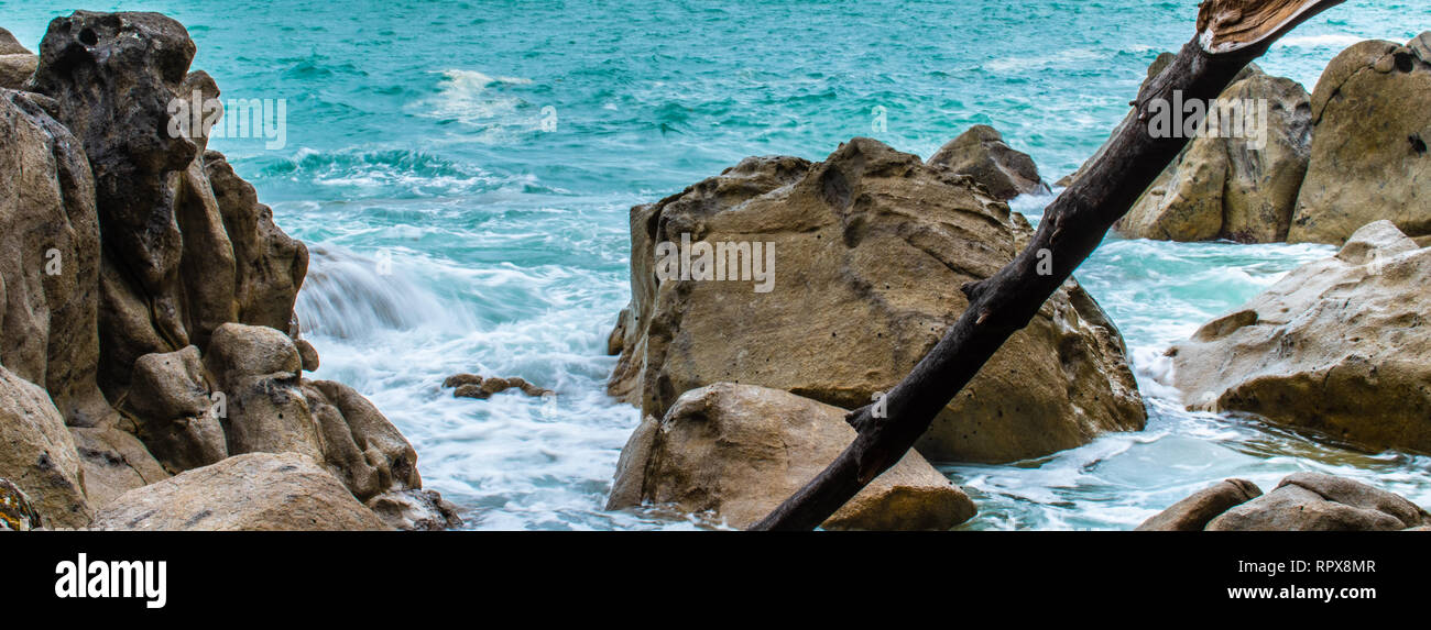 water through rocks against island Stock Photo - Alamy