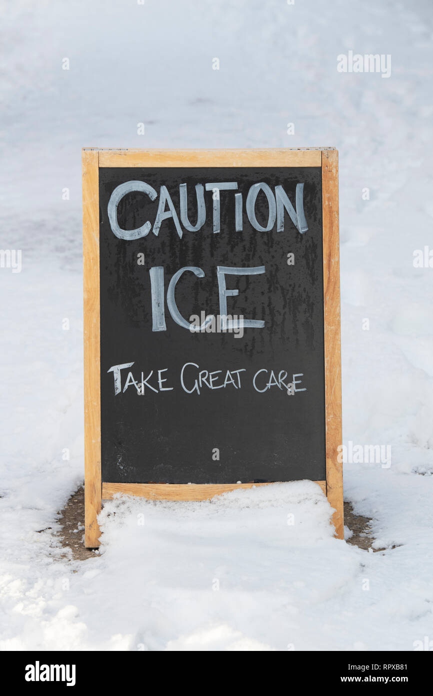 Caution ICE sign on a path in the winter snow. Avebury, Wiltshire ...