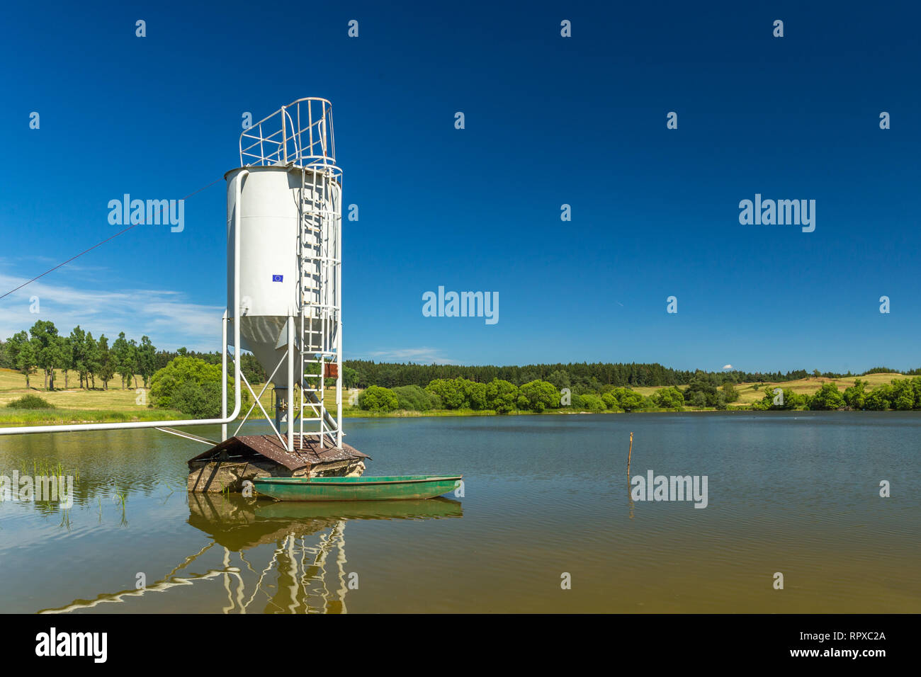 Freshwater fish carp farm with fish food silo Stock Photo - Alamy