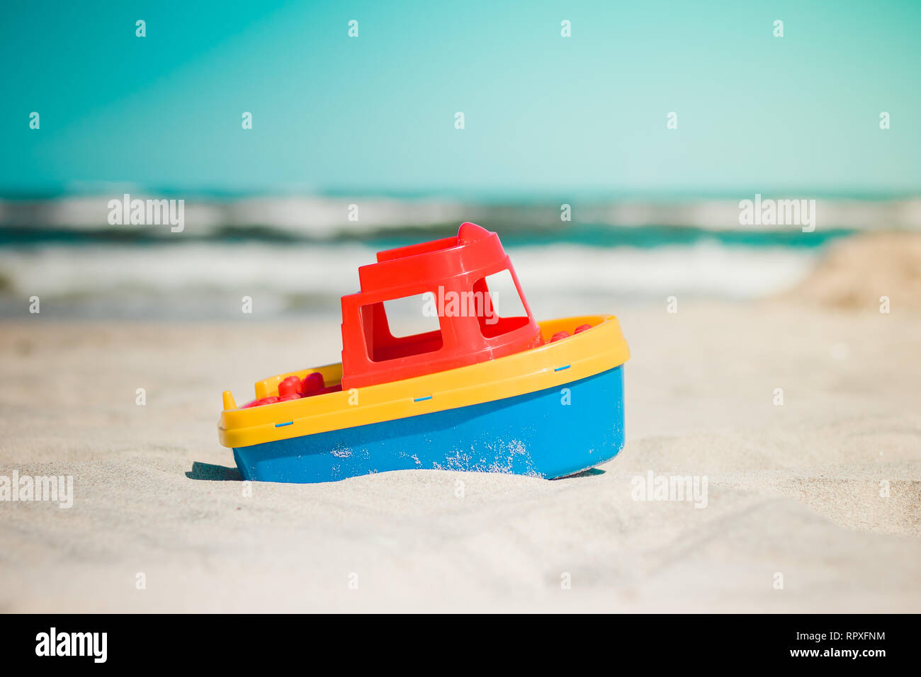 Toy boat on the sand at the beach Stock Photo - Alamy