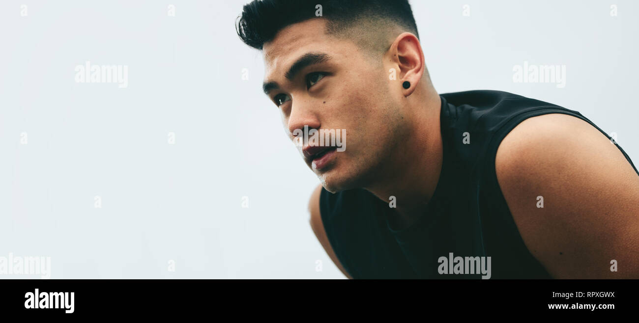 Close up shot of healthy young man looking away. Asian fitness model ...