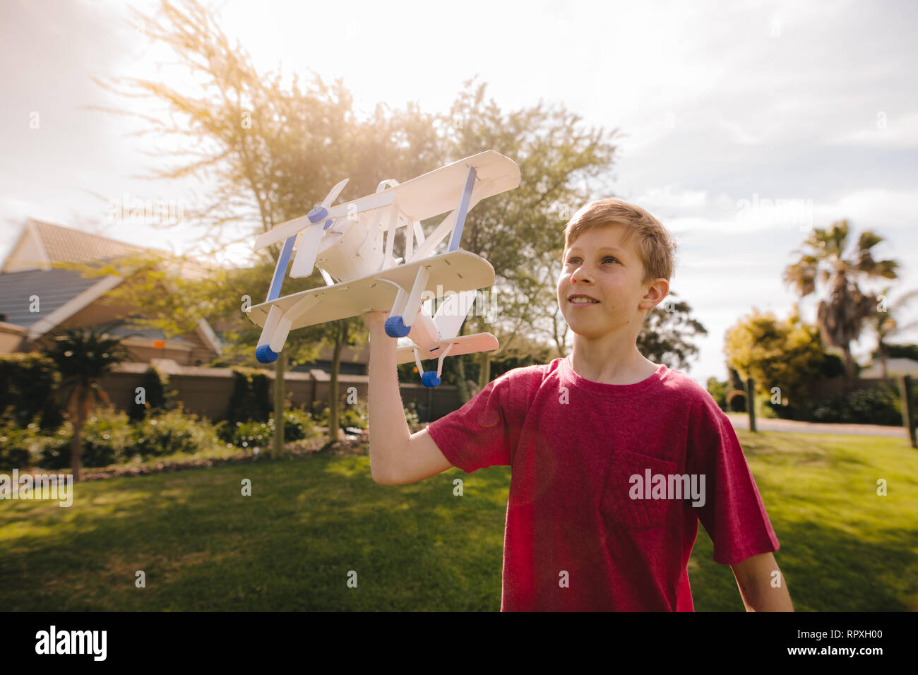 Boy having fun playing with white color toy plane outdoors. Kid playing ...