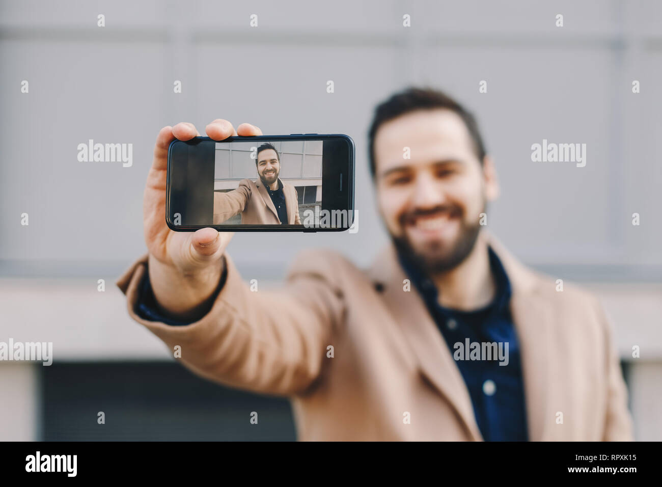 Close-up portrait of attractive and modern young man taking a selfie ...