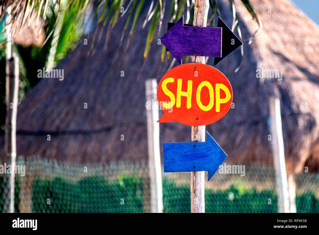 Hand made speech bubble shape shop sign and direction arrows on a post ...