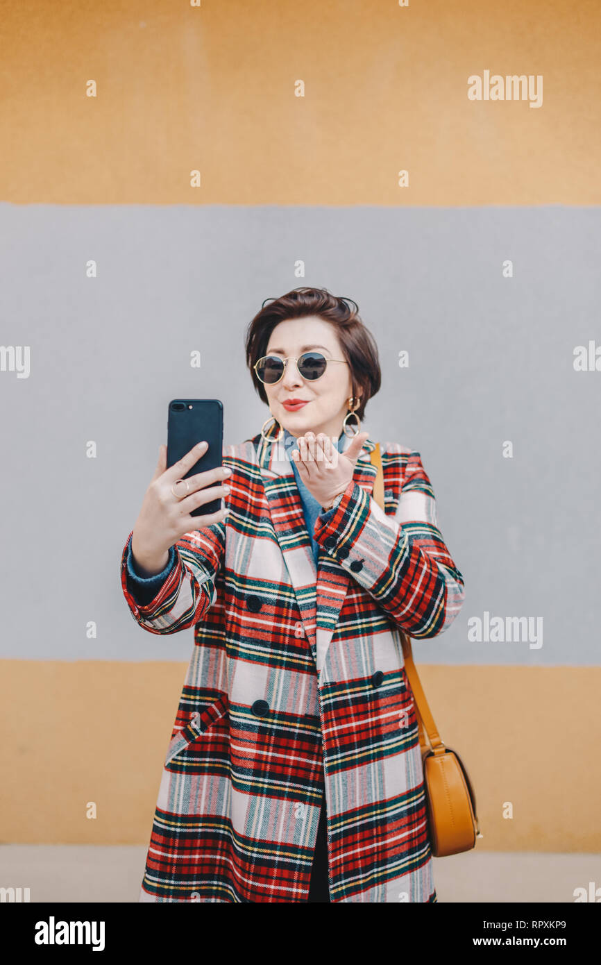 Portrait of modern young influencer taking a selfie with mobile phone ...