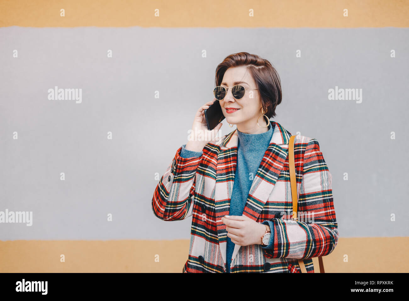 Portrait of attractive, modern young woman having a mobile phone ...