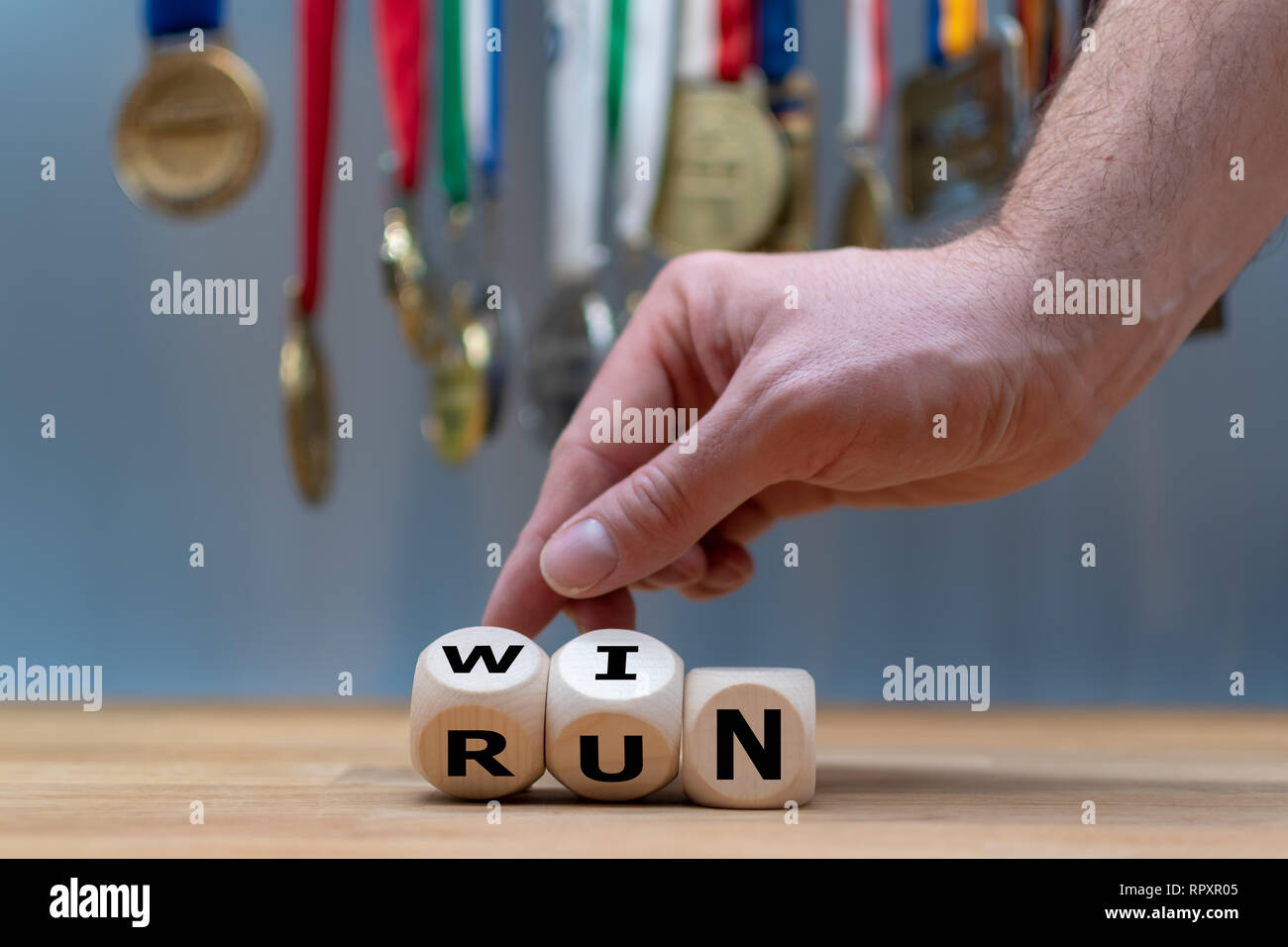 Hand turns a dice and changes the word "RUN" to "WIN" in front of a ...