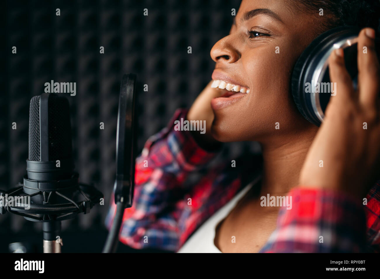 Female singer in headphones songs in audio recording studio. Musician ...